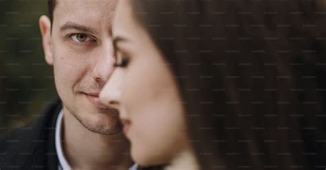 세련된 신랑 모습과 겨울 숲의 나무 아래에서 포옹하는 화려한 신부 겨울 눈 덮인 공원에서 포즈를 취하는 화려한 결혼식 커플 신혼 부부의 낭만적 인 관능적 인 순간 사진