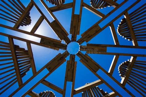 Architectural Wooden Structure With A Complex Pattern Of Intersecting Beams That Frame The Sky