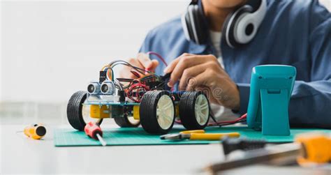 asian teenager doing robot arm project in science classroom stock image