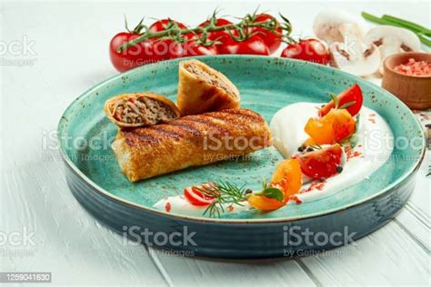 흰색 나무 배경에 사워 크림과 파란색 접시에 고기로 채워진 고전적인 우크라이나어 팬케이크 0명에 대한 스톡 사진 및 기타 이미지