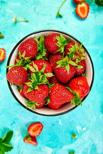파란 테이블에 잘 익은 빨간 딸기 빨간 그릇에 딸기 신선한 딸기 아름다운 딸기 다이어트 음식 건강하고 비건 맨 위 보기 플랫