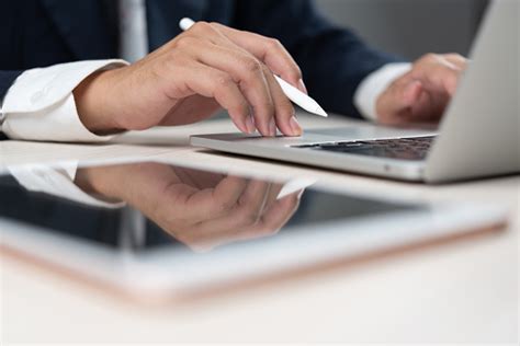 스타일러스 펜으로 노트북에 타이핑하는 사업가는 전문적인 사무 업무를 나타냅니다 현대적인 작업 공간 및 디지털 비즈니스 활동