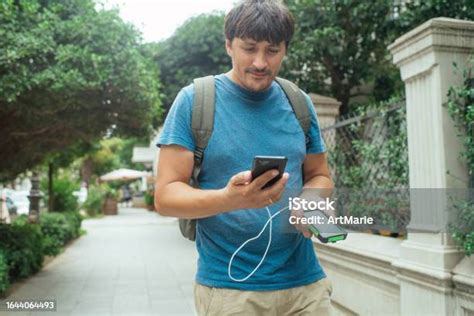 화창한 여름날 도시에서 태양 전지판으로 스마트폰을 충전하는 남자 지속 가능한 라이프 스타일 태양 에너지 생태 대체 에너지 및 생태 개념 45 49세에 대한 스톡 사진 및