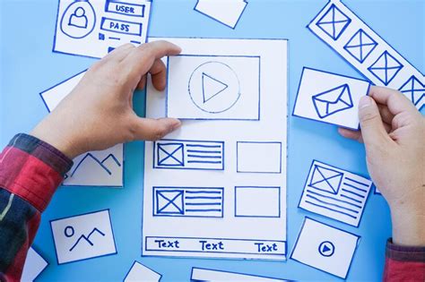 Premium Photo Working Desk With Hands Sorting Wireframe Screens Of Mobile Responsive Website