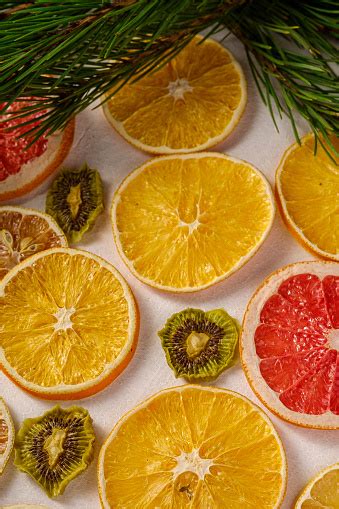 그림자 상단보기 흰색 배경 전나무 나무의 분기와 말린 자몽 키위 오렌지와 레몬 창조적 인 휴일 크리스마스 새해 음식 과일 질감