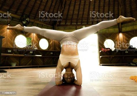 젊은 매력적이 고 건강 한 아시아 인도네시아어 곡예 사 여자 연습 아크로 요가 운동에 균형 포즈 전통적인 스튜디오에서 훈련에 집중 하모니와 웰빙 라이프 스타일 건강한 생활