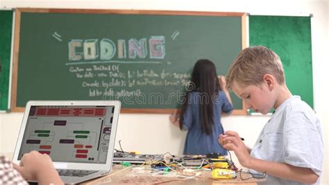 Asian Boy Coding Program While Friend Fixing Electric Board At Class