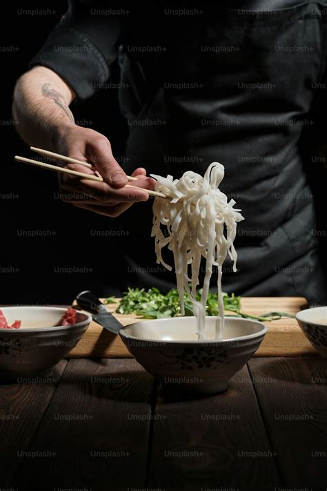 Close Up Of Chefs Hands Picking Noodles From The Bowl Photo Noodles