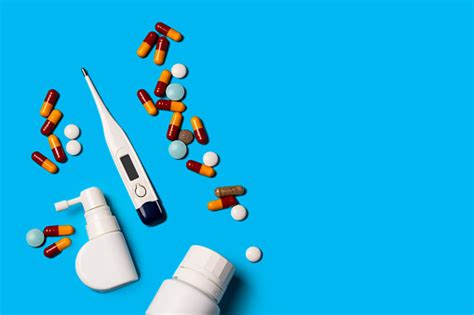 의료 건강 관리 정물 파란색 배경에 다른 색상의 약 알약 정제 및 Suplement 캡슐 의료 Spary 약물 병 및 디지털 온도계 상의 View 개념에 대한 스톡 사진 및