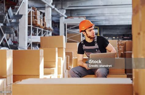 제복을 입고 현대적인 노트북을 손에 들고 있는 스토리지 작업자가 생산을 점검합니다 18 19세에 대한 스톡 사진 및 기타 이미지 18 19세 건설 산업 경영자