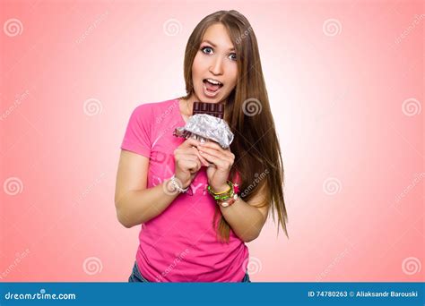Женщина красоты модельная есть темный шоколад Красивая удивленная молодая женщина принимает