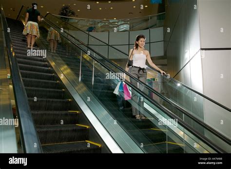 Two Women On Escalator Stock Photo Alamy