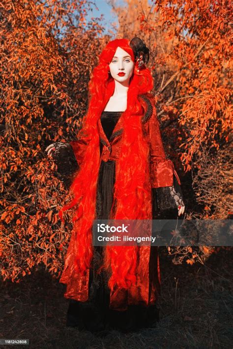 고딕 할로윈 코트입니다 가을 배경에 젊은 중세 여왕입니다 빨간 머리를 가진 여자 창백한 피부뱀파이어 할로윈을위한 중세 의상 고딕