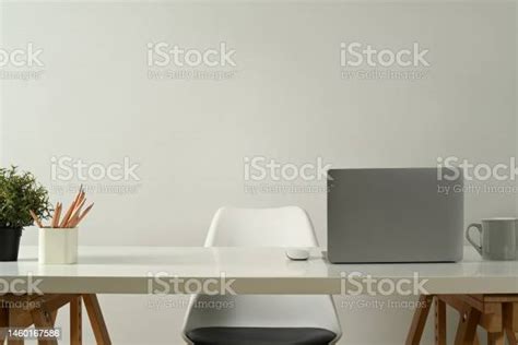 노트북 컴퓨터 연필꽂이 커피 컵 흰색 테이블에 화분에 심은 식물이 있는 현대적인 홈 오피스 인테리어 모던 양식에 대한 스톡 사진