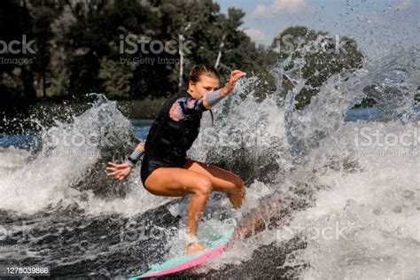 아름다운 여자는 서핑 스타일의 웨이크 보드에 구부러진 무릎을 들고 파도에 타고 서 30 39세에 대한 스톡 사진 및 기타 이미지 30 39세 건강한 생활방식 검은색