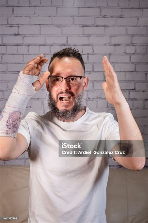 안경을 쓴 남자는 아이들의 그림과 흰색 티셔츠가 있는 부목으로 부러진 팔을 보여줍니다 40 44세에 대한 스톡 사진 및 기타 이미지 40 44세 Centers For