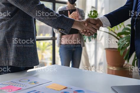 고객과 은행가가 사업 투자 예산이 완료된 후 회의 테이블에서 악수하는 손 악수하는 사업가들 사업 거래 완료 함께 사업을 하기로 동의 New Partnership For