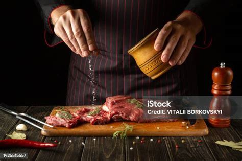 요리사는 구워 먹거나 굽기 전에 신선한 쇠고기를 소금에 절입니다 레스토랑이나 호텔의 주방에서 일하는 환경 요리사에 대한 스톡 사진 및 기타 이미지 Istock