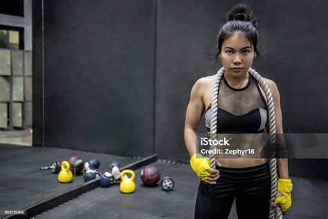 젊은 아시아 체조 여자 체조 로프 어깨에 운동이 나 피트 니스 체육관에서 운동에 대 한 다른 장비와 함께 포즈 거울에 대한 스톡