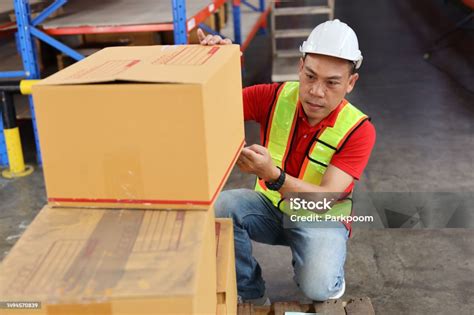 Saftyhat 및 반사 재킷 체크리스트를 가진 창고 작업자 남자 또는 소매 창고 물류 유통 센터의 생산 재고 및 재고로 배달하기 위한 대형 상자 패키지를 제어합니다 30
