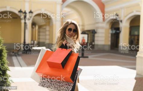 성공적인 쇼핑 그녀의 손에 들고 젊은 매력적인 유럽 여성은 다양한 의류 및 신발 상점에서 쇼핑 패키지를 많이 들고 여자에 대한