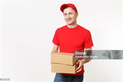 배달 젊은이 빨간색 유니폼에 흰색 배경에 고립 모자 티셔츠 택배 또는 두 개의 빈 골 판지 상자를 들고 하는 딜러로 일하고 있는 남자 수신 패키지입니다 광고에 대 한 공간을