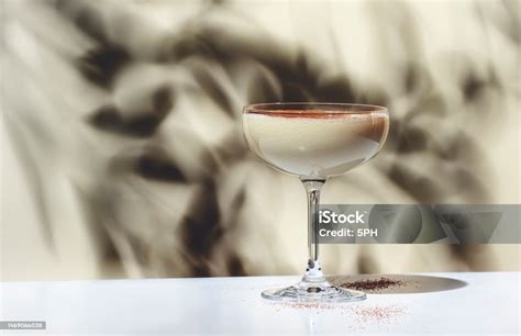 브랜디 알렉산더 알코올 칵테일 음료는 코냑 코코아 주류 크림 육두구 및 얼음으로 마신다 밝은 베이지색 배경 하드 라이트 그림자 패턴 크림 유가공 식품에 대한 스톡 사진 및