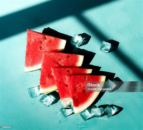 파란색 배경에 슬라이스 수박 직접 태양 빛과 날카로운 그림자 아래 얼음 조각 수박 상단 보기 플랫 레이 0명에 대한 스톡 사진 및 기타 이미지 Istock