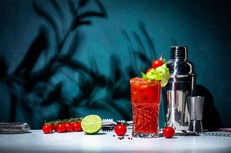 블러디 메리 칵테일 음료는 토마토 주스 보드카 레몬 셀러리 핫 소스 얼음을 소금과 칠리 페퍼로 장식한 유리잔에 담습니다 짙은 녹색 배경 하드 라이트 및 그림자 패턴 0명에