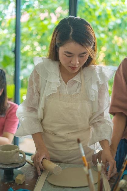 도자기 워크샵에서 점토로 세라믹 냄비를 만드는 포터 휠에서 일하는 아름다운 여성 도공 미래 세라믹 제품에 점토 제품 부품을