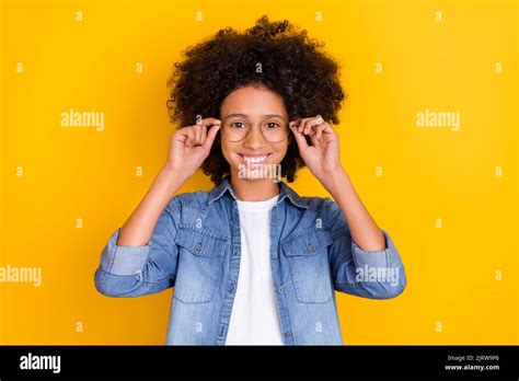Portrait Of Attractive Cheerful Teen Girl Nerd Touching Eyewear Isolated Over Bright Yellow