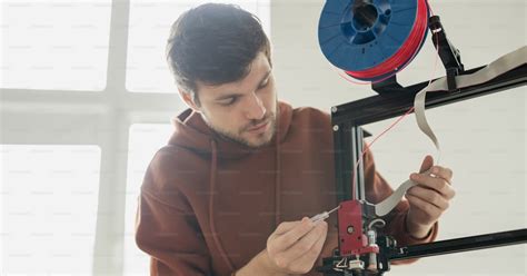 3d 프린터의 프린트 헤드를 수리하거나 작업 프로세스 전에 후면 패널을 고정하는 드라이버를 가진 젊은 엔지니어 사진 Unsplash의 사진술 이미지