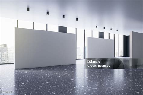 어두운 콘크리트 바닥과 파노라마 창문에서 도시 전망이 있는 햇볕이 잘 드는 빈 갤러리 홀에서 광고 또는 포스터를 위한 공간이 있는 빈 조명 파티션의 투시도 3d 렌더링 모형