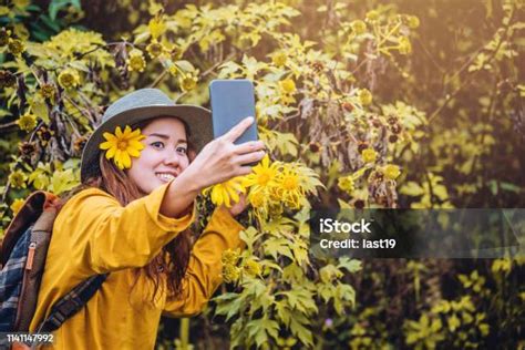 배낭과 소녀는 셀 카를 촬영 하는 전화를 사용 하는 부아 통 꽃 노란색의 사진 멕시코 해바라기 계곡에 대한 스톡 사진 및 기타 이미지 Istock