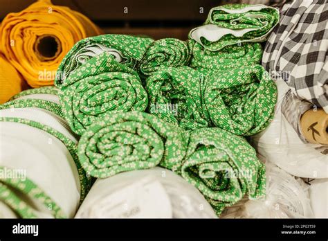 A Collection Of Vibrant Green Knitted Fabric Rolls Arranged In A Neat