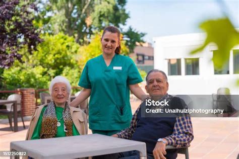 요양원이나 양로원의 정원에서 간호사와 함께 있는 두 노인 노인과 노인의 초상화 노인에 대한 스톡 사진 및 기타 이미지 노인 원조 의료 관련 직업 Istock