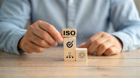 Person Stacking Iso Wooden Blocks With Target Business Structure And Atom Icons On A Wooden