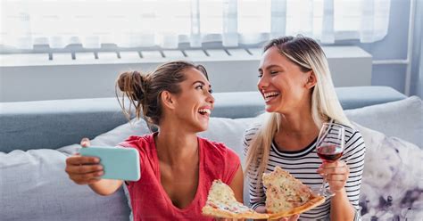 피자를 먹고 셀카를 위해 웃는 친구들 그들은 피자를 공유하고 스마트 폰에서 셀카 사진을 만들고 있습니다 사진 Unsplash의 앉아 이미지