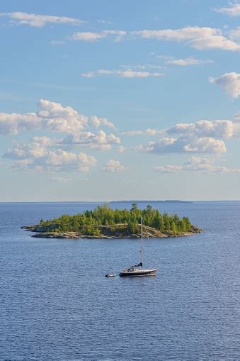 물 속에 요트가 있는 호수 한가운데에 있는 작은 숲이 우거진 섬의 수직 사진 0명에 대한 스톡 사진 및 기타 이미지 0명 경관 관광 Istock