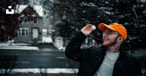 검은 재킷과 주황색 모자를 쓴 남자가 주황색 모자를 들고 있다 사진 Unsplash의 무료 미국 이미지