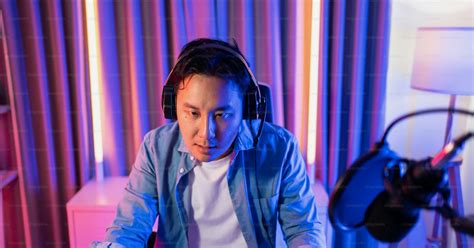 아시아의 매력적인 Esport 남성 게이머는 컴퓨터에서 온라인 비디오 게임을합니다 잘 생긴 남자 게임 플레이어는 행복하고 흥분을 느끼고 집에서 사이버 토너먼트를하는 동안