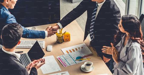 그룹 비즈니스 사람들은 사무실의 회의 테이블에서 악수하고 탑 뷰에서 자신감 있는 샷을 합니다 젊은 사업가와 여성 사업가들은 투자 거래에 대한 동의를 표명합니다 사진