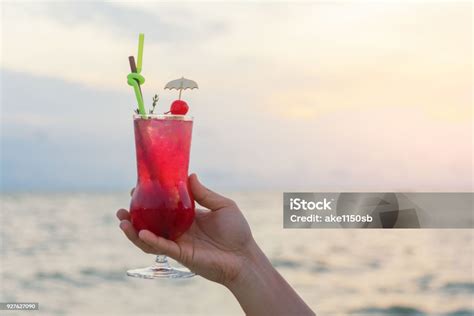황혼의 바다 및 하늘 배경에서 빨간 칵테일 음료를 들고 손을 여름 휴가 여행 및 휴가 개념입니다 0명에 대한 스톡 사진 및 기타 이미지 Istock
