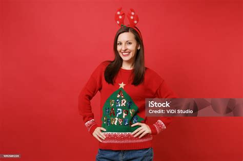 미소에 장식 사슴 뿔 머리 밝은 빨간색 배경에 고립 된 두 팔으로 서 재미 있는 산타 소녀 행복 한 새 해 2019 축 하 휴일