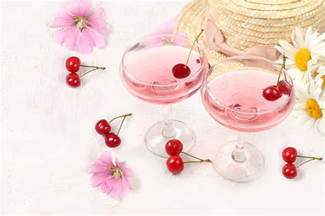 밝은 배경에 여름 트렌디한 배너입니다 밀짚모자 에코백에 담긴 과일 상쾌한 알코올 음료 햇볕이 잘 드는 테이블에 카모마일 꽃 휴가