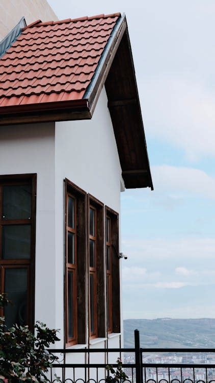 경치 좋은 전망을 바라보는 붉은 지붕의 매력적인 코티지 · 무료 스톡 사진