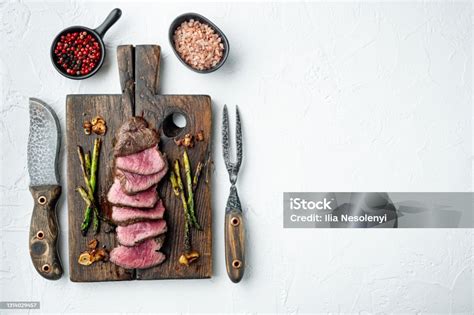 구운 필렛 미뇽 쇠고기 스테이크 양파와 아스파라거스 나무 서빙 보드에 고기 칼과 포크 흰색 돌 배경 상단 보기 플랫 레이 텍스트 복사 공간 소고기에 대한 스톡 사진 및 기타