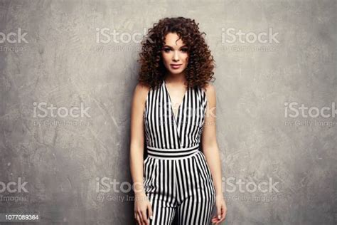 패션 모델 소녀 회색 배경 위에 절연입니다 뷰티 스튜디오에 유행 옷을 입고 포즈를 취하는 세련 된 갈색 머리 여자 캐주얼 스타일 뷰티 액세서리입니다 높은 패션 도시 스타일