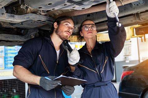 기술자 작업자는 렌치 도구를 사용하여 차 아래 유지 보수 자동차 엔진을 사용합니다 차고에서 자동차 상태 하에서 정비사 차량 서비스 유지 보수 점검 그룹 기계공에 대한 스톡