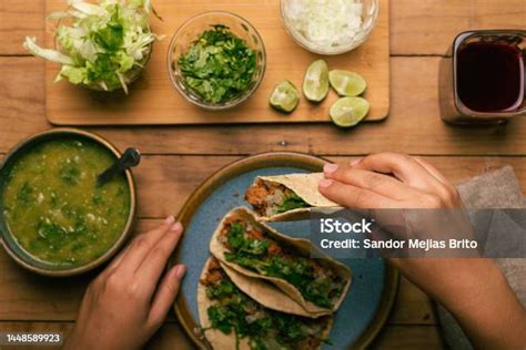 절인 고기의 타코를 들고 있는 여자의 손 나무 테이블에 타코 소스 및 야채와 접시 평면도 거리에 대한 스톡 사진 및 기타 이미지 Istock